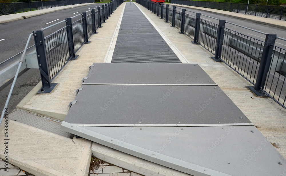 the space between the lanes of the highway bridge is blocked by a grid ...