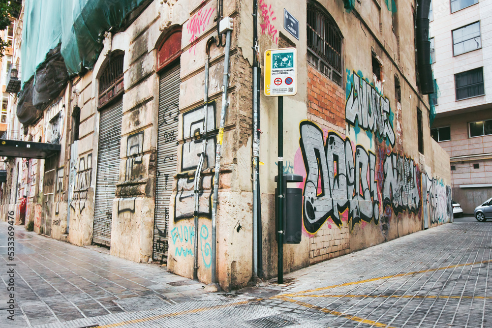 A grungy street corner with graffiti painted on the decaying wall Stock ...