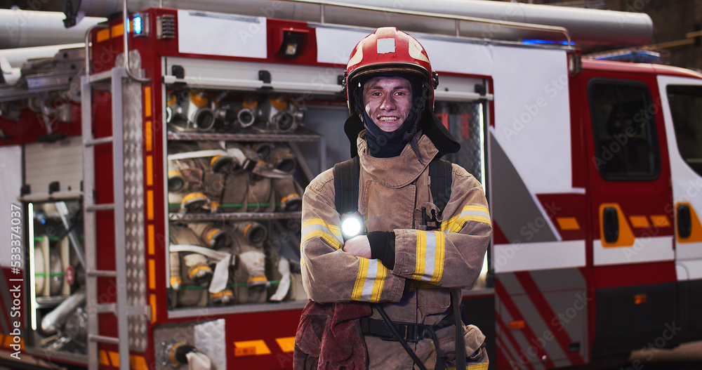 Middle plan of satisfied fireman in helmet and gull equipment cross ...