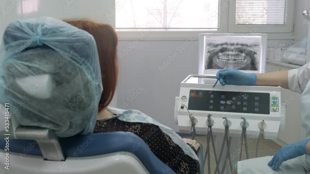 Video „Dentist showing to patient teeth x-ray sitting next to the chair ...