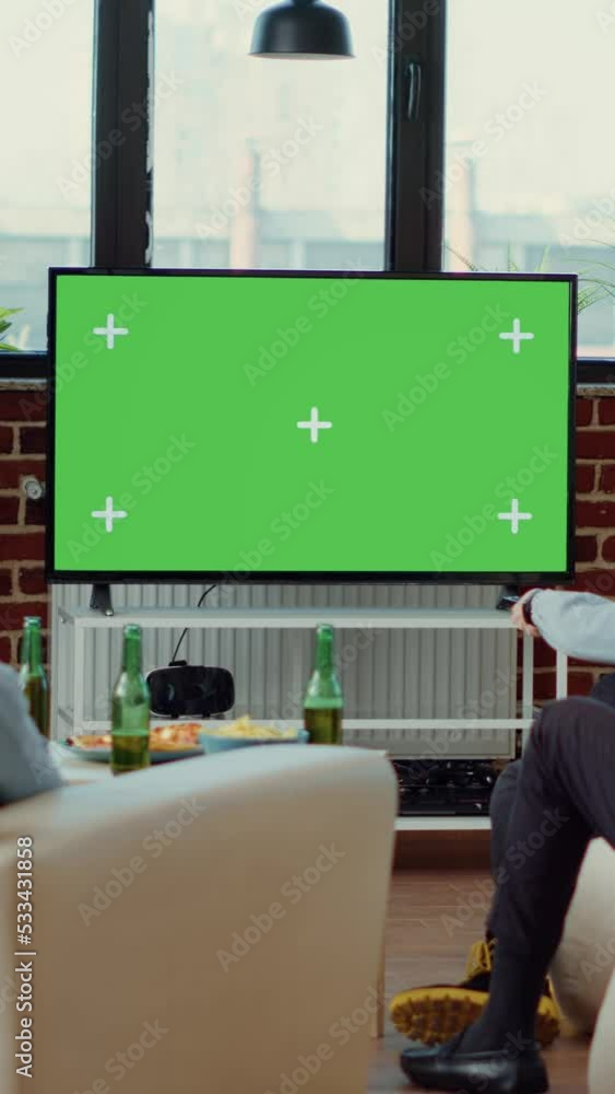 Vertical video: Diverse people switching tv channels on greenscreen ...