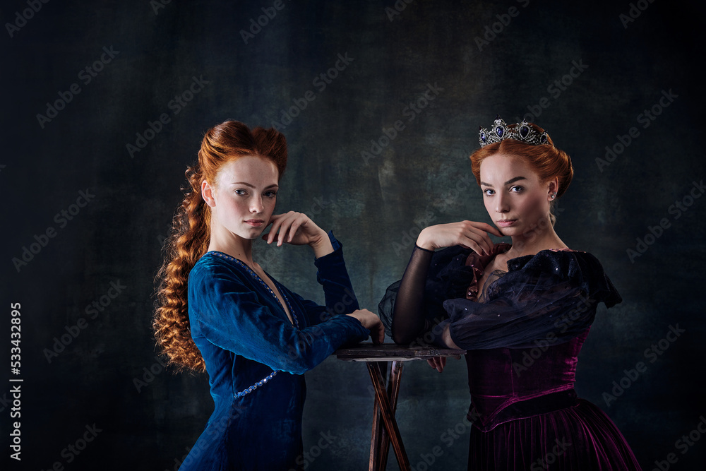 Portrait of two beautiful women in image of queen and princess isolated ...