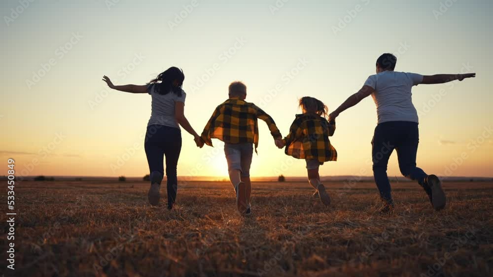 happy family run. friendly family runs holding hands in the park ...