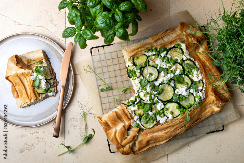 Zucchini and cheese phyllo dough tart with green peas, micro greens and ...