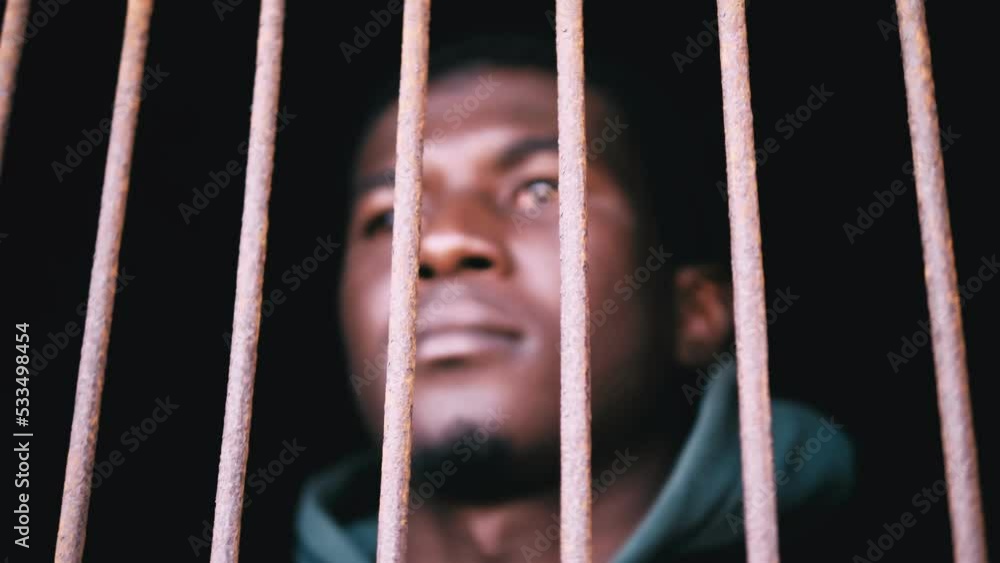 serious black man in prison, behind bars. Justice, prison, crime Stock ...
