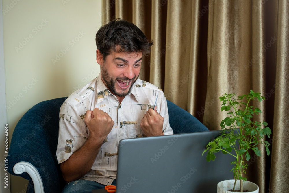 Foto de Hombre contento festejando después de realizar una compra on ...