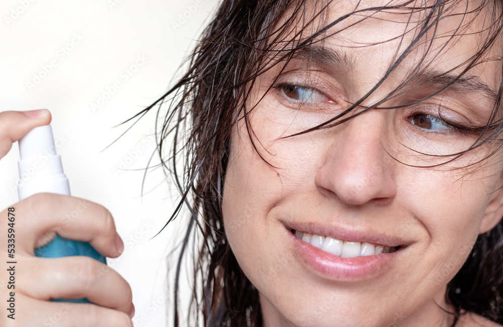 woman using spray on wet hair isolated.smiling girl with wet hair long ...