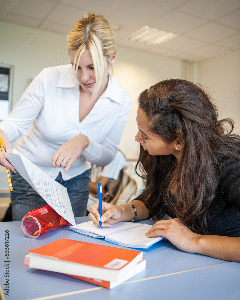 Teenage Students: Teaching Assistance. A form teacher helping a student ...