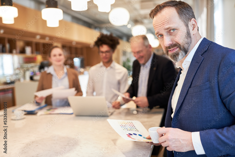 Senior businessman as manager with team in background Stock Photo ...
