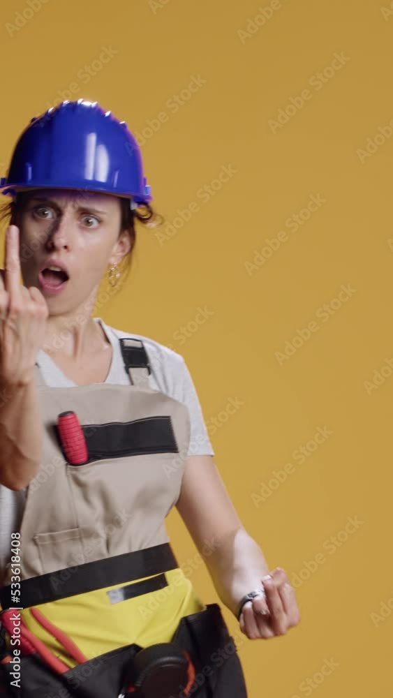 Vertical video: Portrait of rude handywoman giving middle finger on ...
