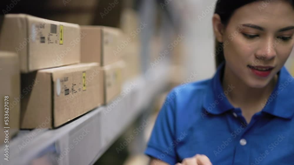 Hand of female worker in blue uniform checklist manage parcel box ...