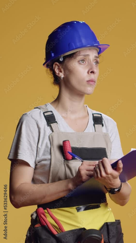Vertical video: Portrait of construction worker taking notes and doing ...