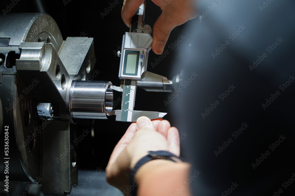 Hands of an engineer measures a metal part with a digital vernier ...