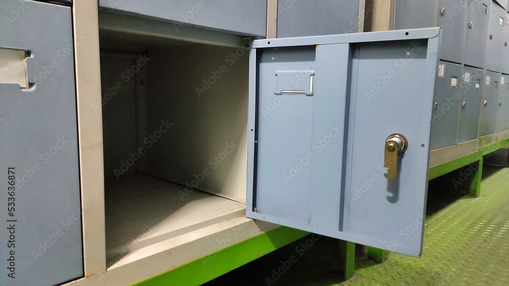 Interior background of old blue grey opened locker in the locker room ...