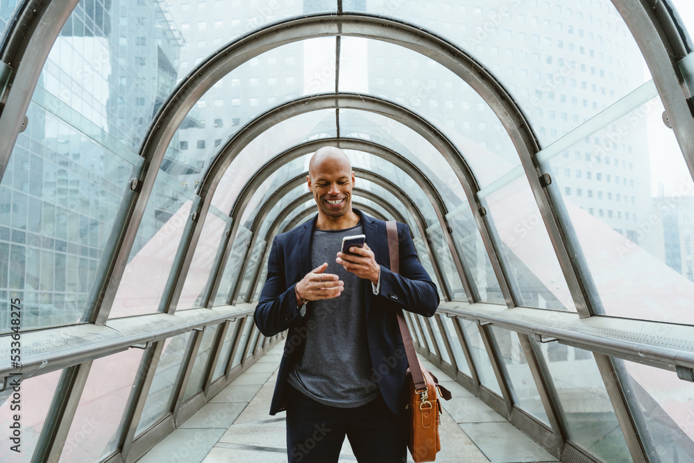 Young business man going to work in the morning passing by an urban ...