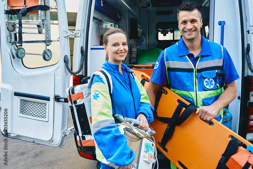Emergency medical technicians standing near ambulance. Personnel of ...