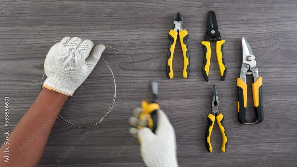 Footage of hand wearing white gloves cut steel wire using combination ...