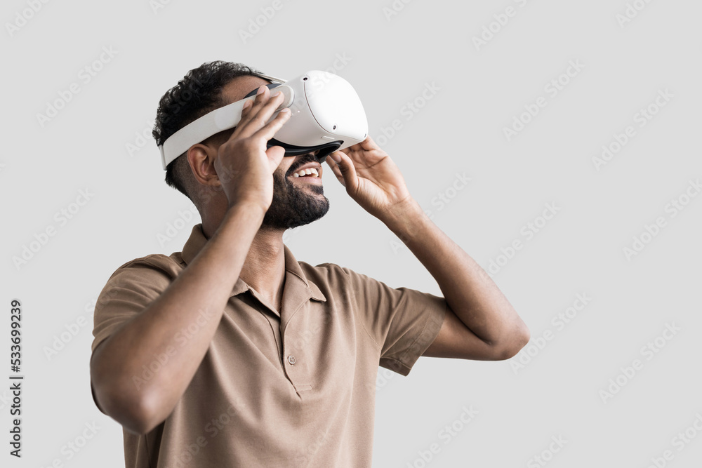Young man using virtual reality headset isolated on gray background, VR ...
