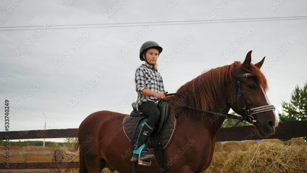 portrait of little girl jockey on horseback in equestrian club, child ...