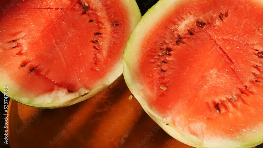 a woman cut a ripe watermelon into two halves and parted the parts of ...