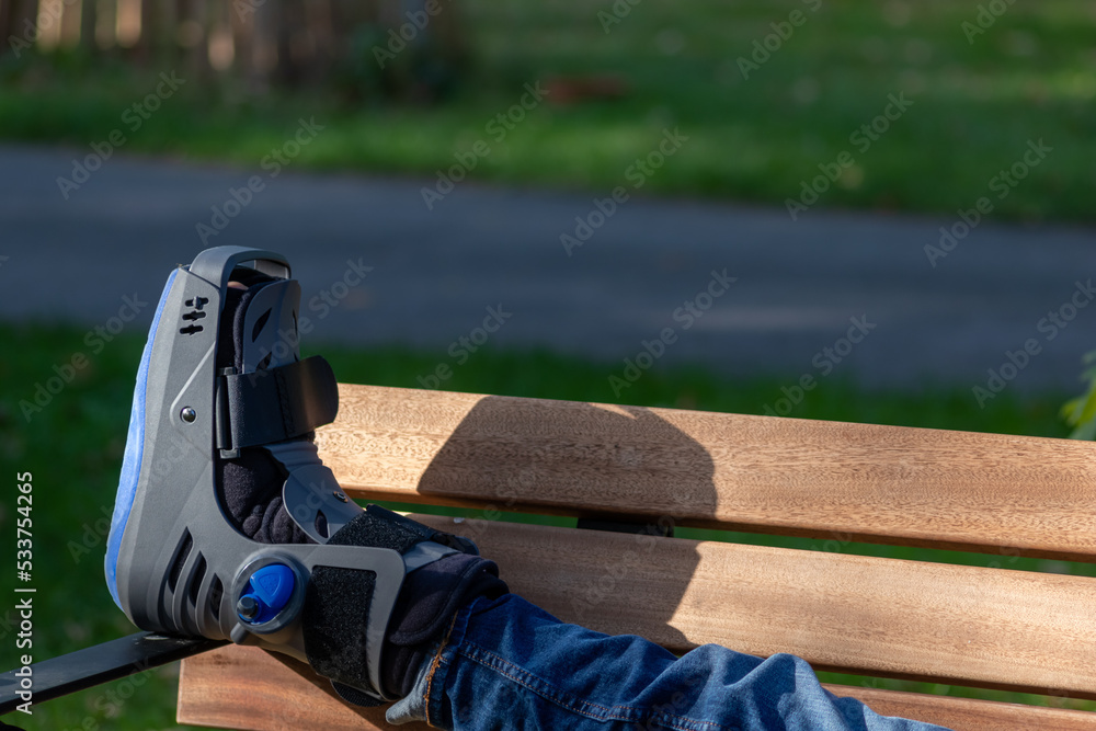 Boy with broken foot and orthopedic shoe or walker after bone fracture ...