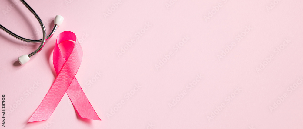 Breast Cancer Awareness Month. Pink ribbon and stethoscope on colored ...