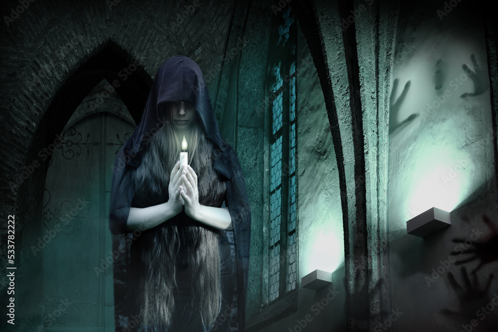 young female witch, black lady with long hair holds candle in her hands ...