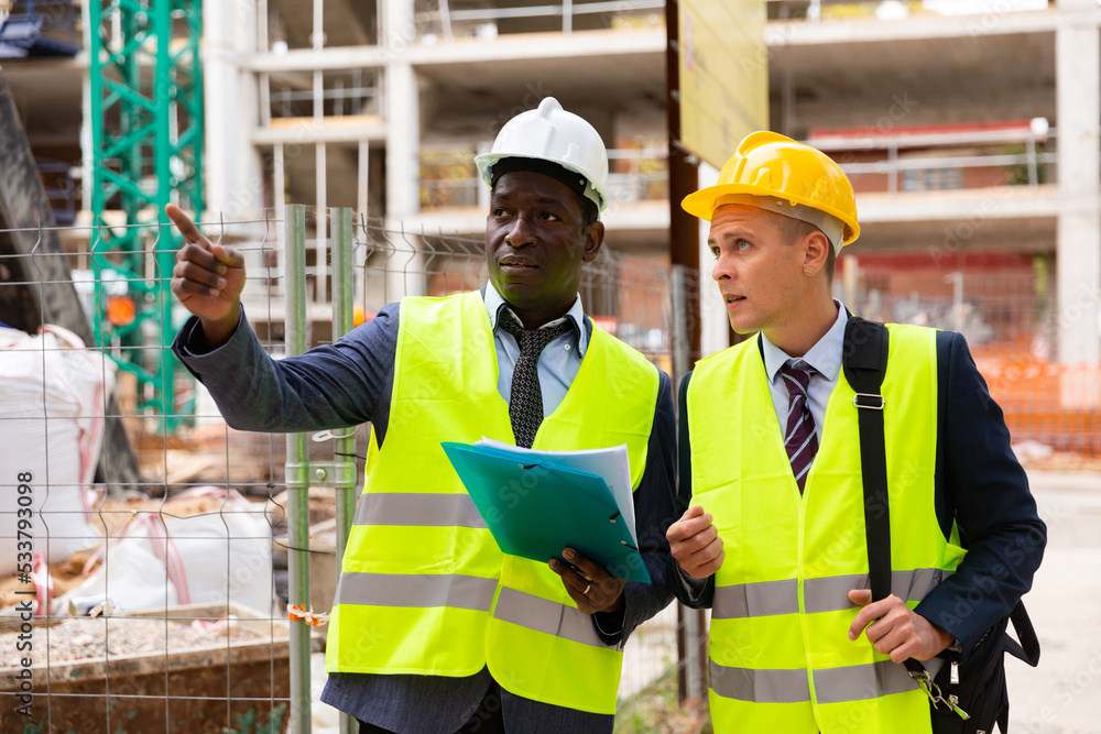 African-american civil engineer discussing a construction plan with a ...