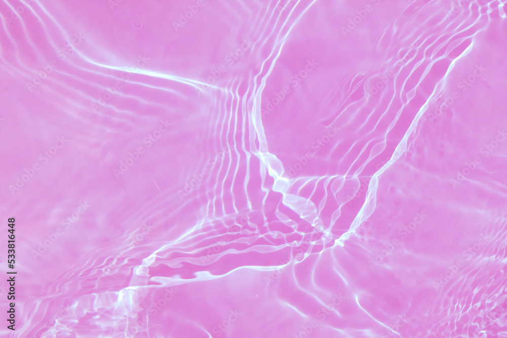 Defocus blurred transparent pink colored clear calm water surface ...