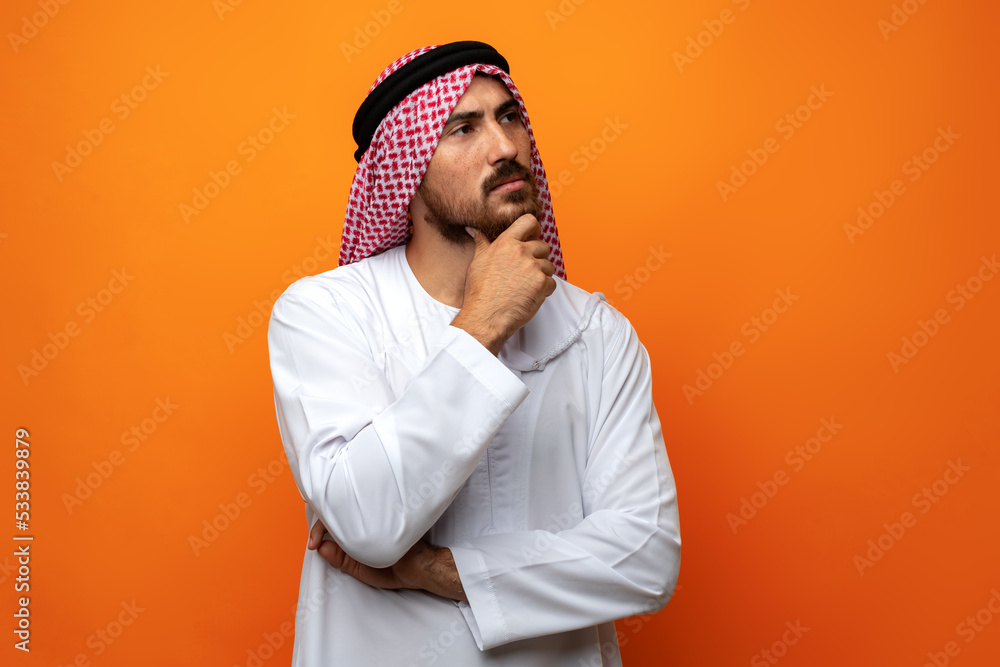 Young arab man wearing traditional clothes thinking about something ...