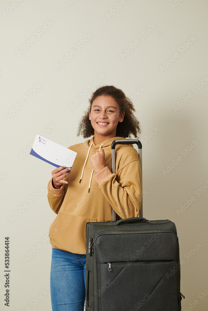 Excited College Girl with Suitcase ภาพถ่ายสต็อก | Adobe Stock