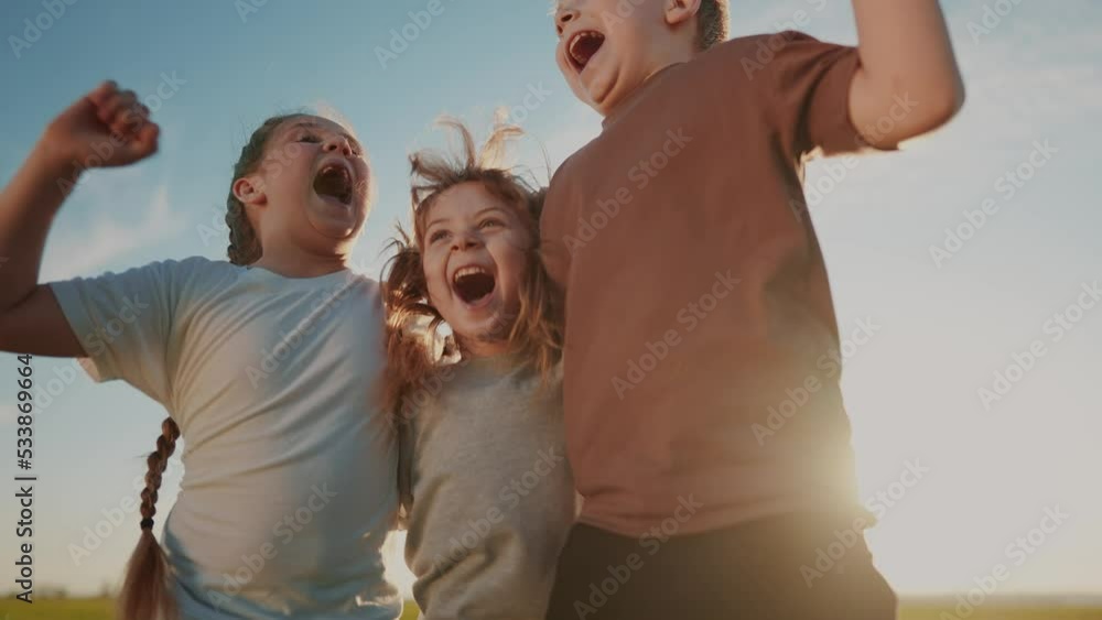 group of kids team hugging a jumping and rejoicing outdoors. happy ...