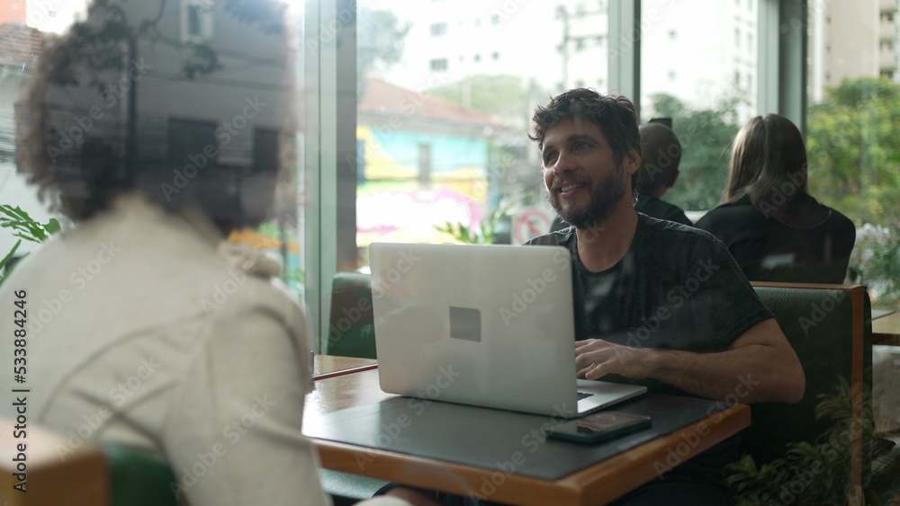 People inside coffee shop through glass window. Men and women customers ...