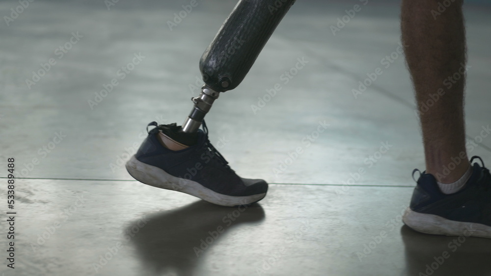 Disabled person walking with his prosthetic leg indoors. Amputee man ...