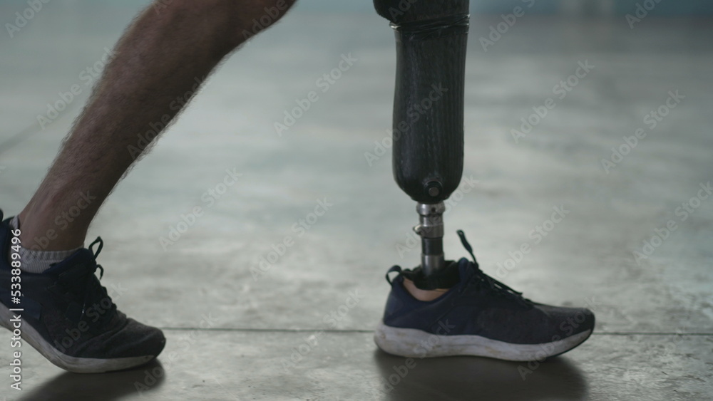 Disabled person walking with his prosthetic leg indoors. Amputee man ...