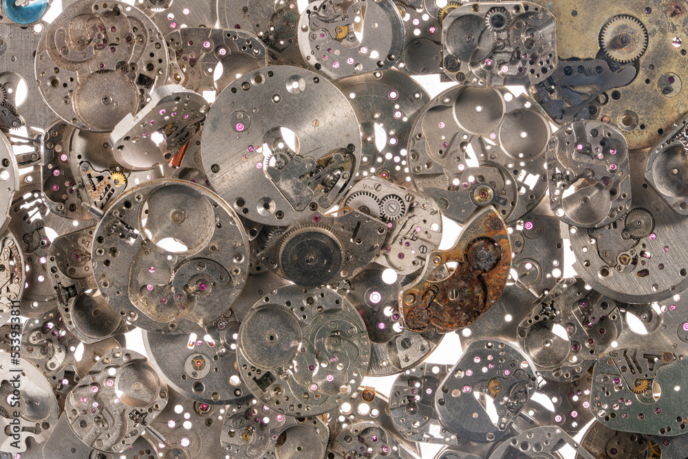 Top view of heap of metal internal parts of an old clock on a white ...