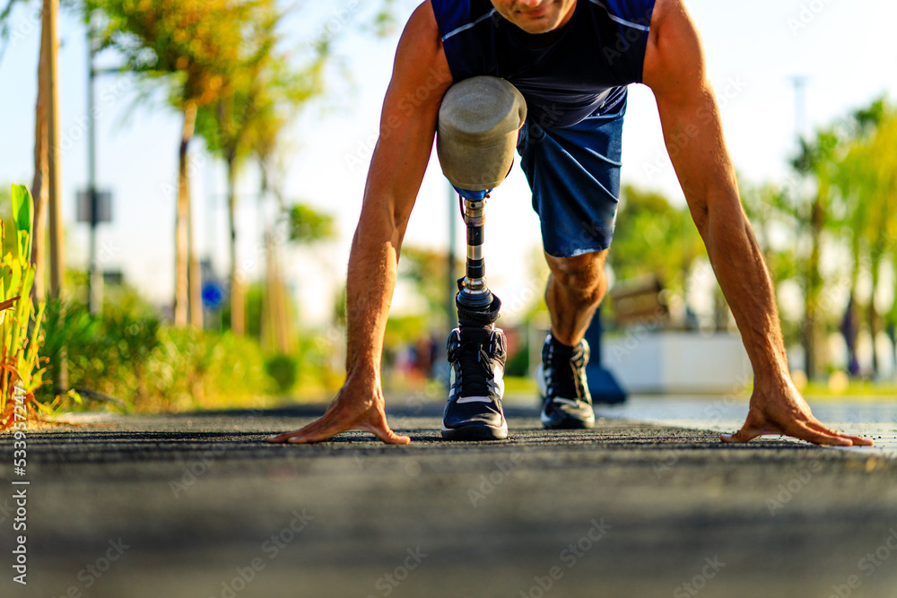 disabled athlete man with prosthetic leg starting to run at the beach ...