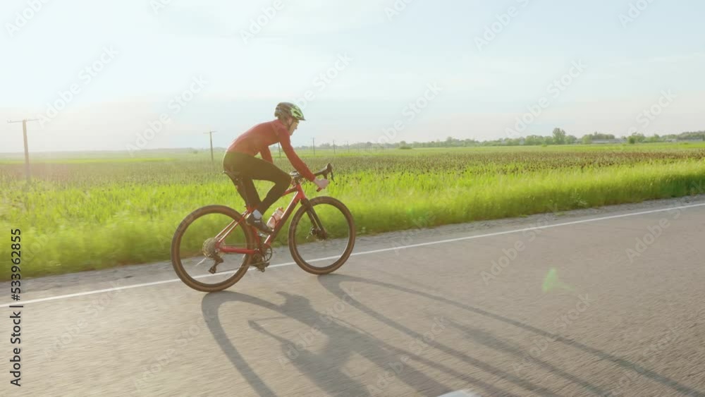 Strong cyclist wearing sport clothes training on road bicycle during ...