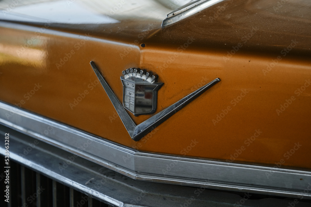 Old American Cadillac car. Brands logo on orange body of car, close-up ...