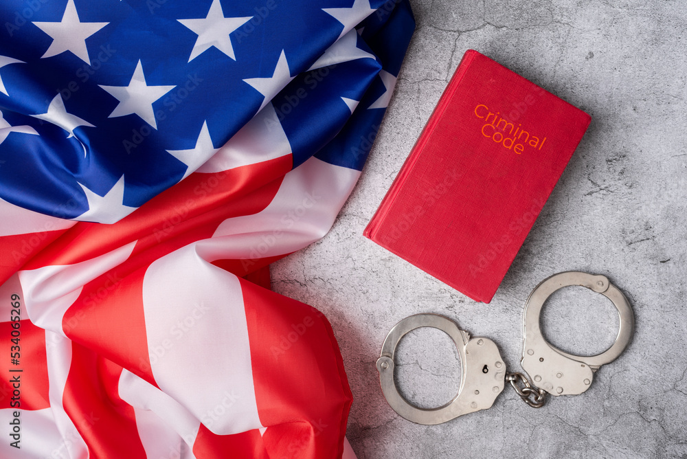 Background with United States flag next to criminal code and handcuffs ...