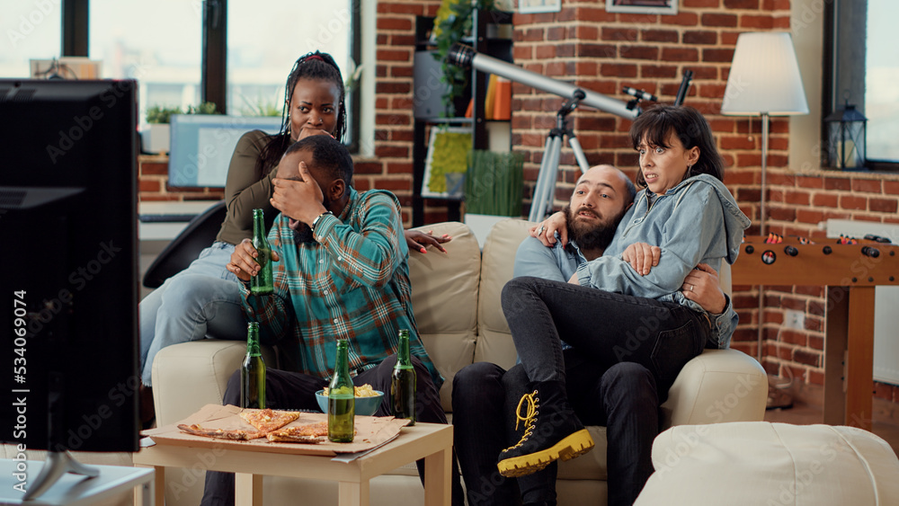 Terrified people watching scary movie on tv channel, being frightened ...