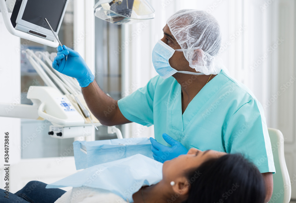 Confident stomatologist showing teeth radiography result on computer ...