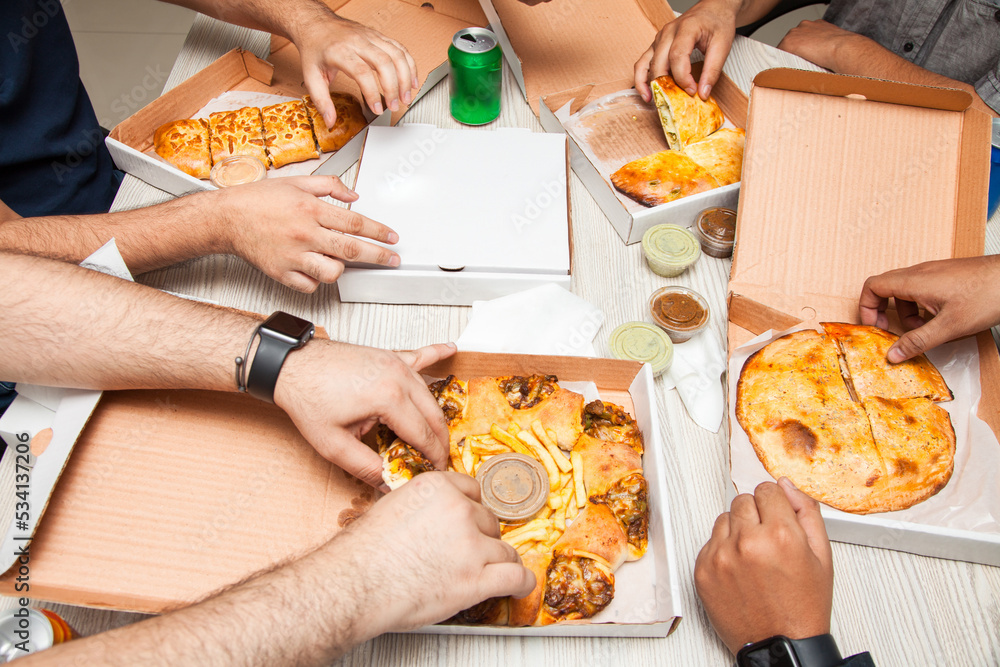 Feast of delivered pizza flatbread stuffed naan shared amongst friends ...