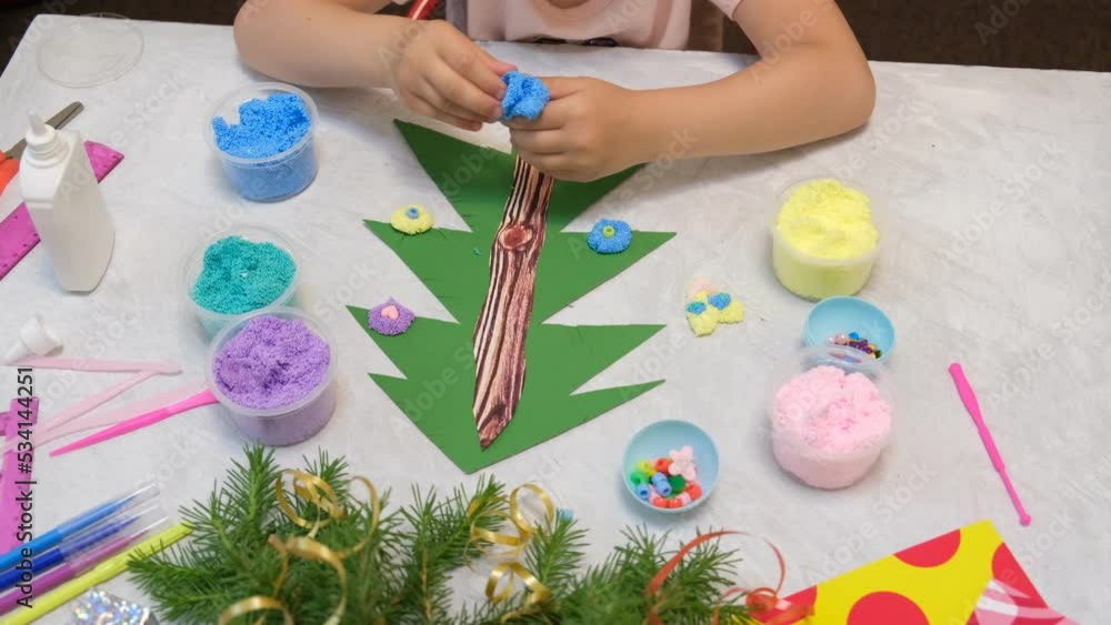 Child makes a greeting card Christmas paper and foam plasticine craft ...