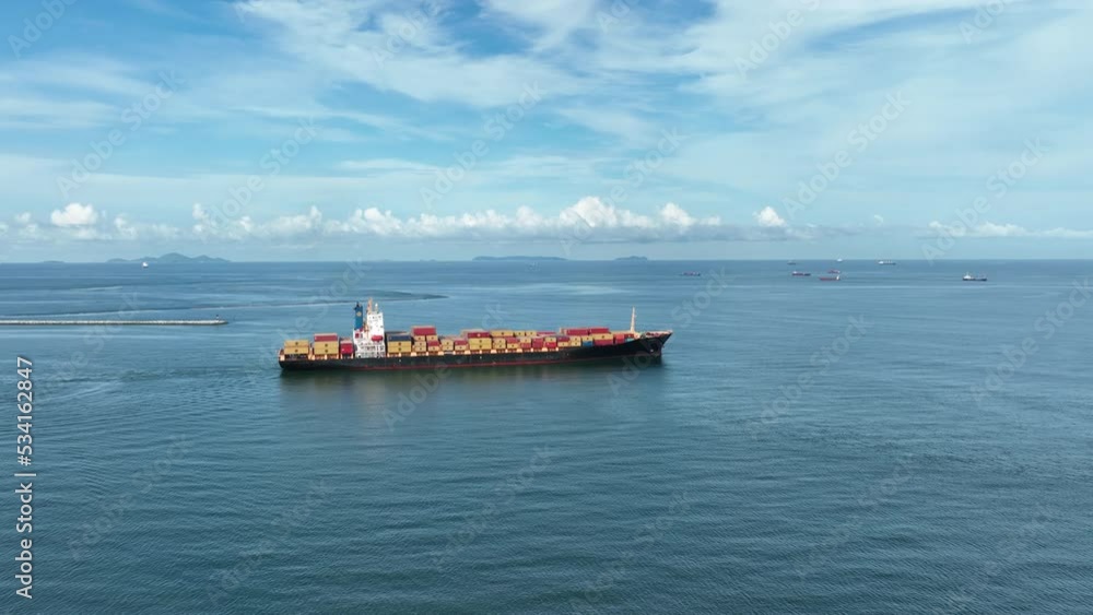 Aerial side view of cargo ship carrying container and running for ...