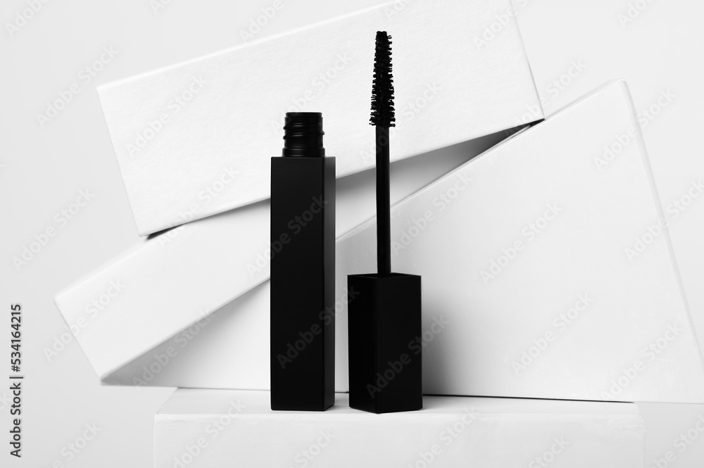 Black mascara and brush with geometric shapes on white background ...