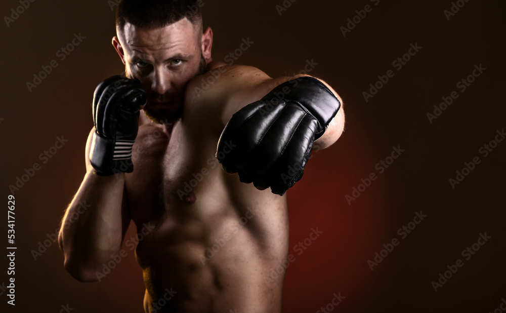 Studio portrait of fighting muscular man in black fighting gloves ...