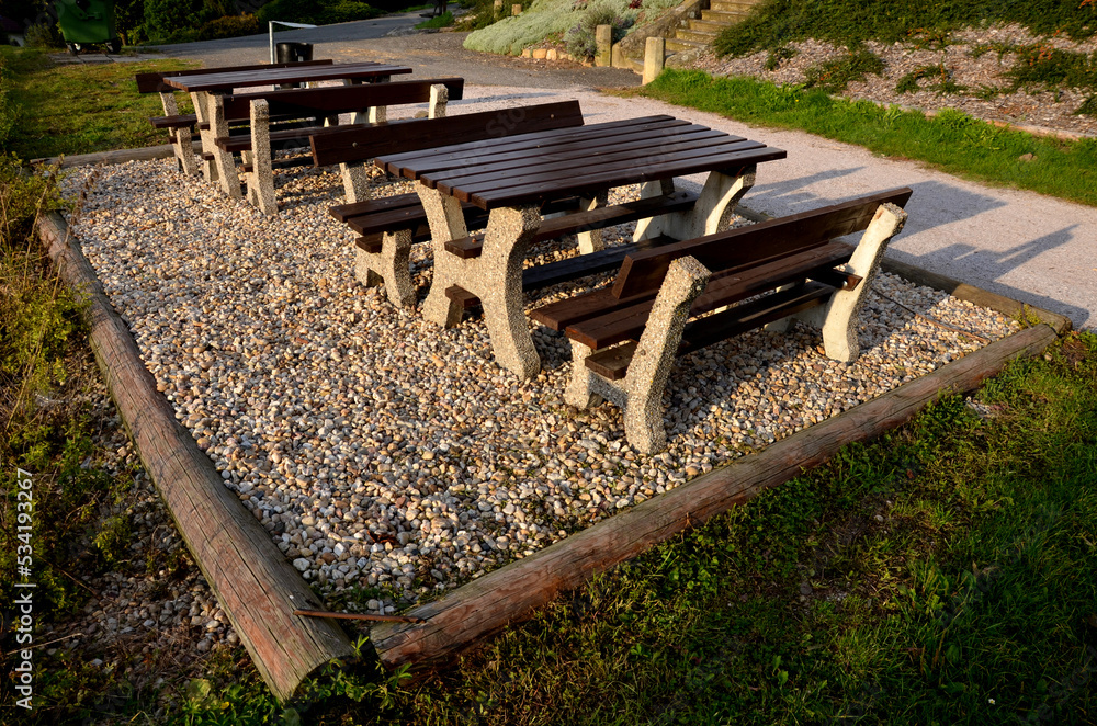 Foto de Wooden benches on the promenade in the park. massive concrete ...