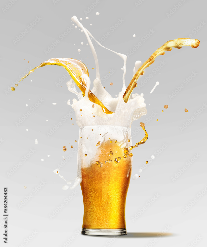 Foam splashes from full glass of frothy light lager beer isolated over ...