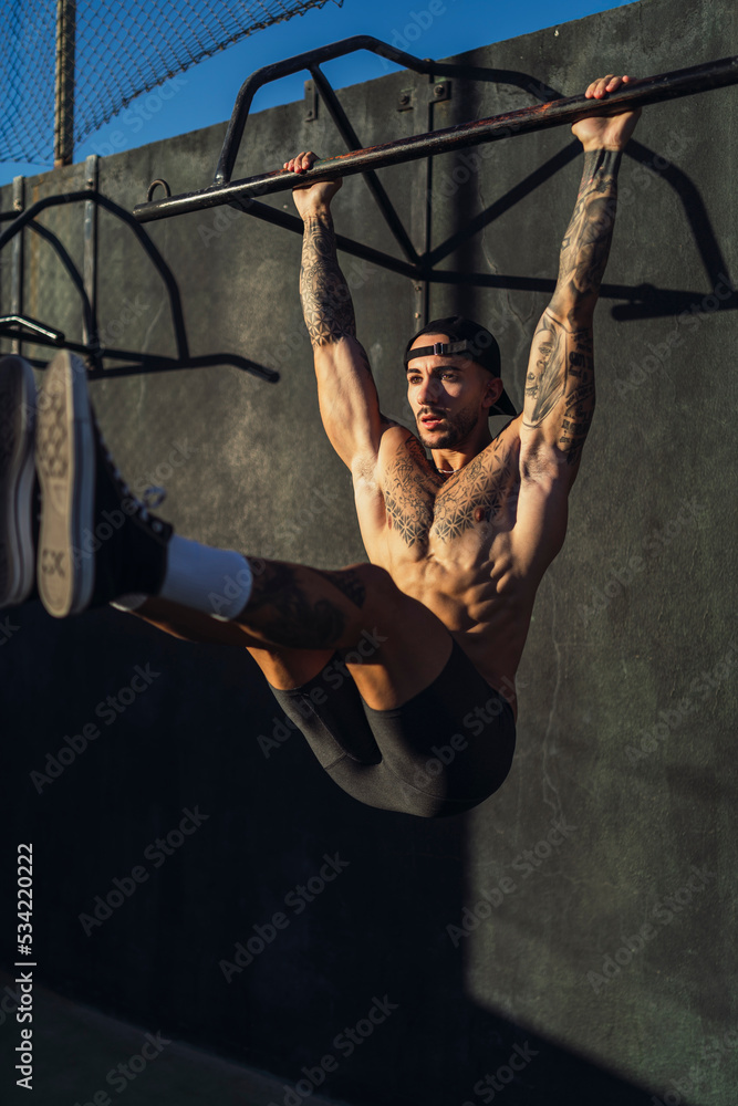 Chico joven musculado haciendo ejercicio y posando en gimnasio al aire ...